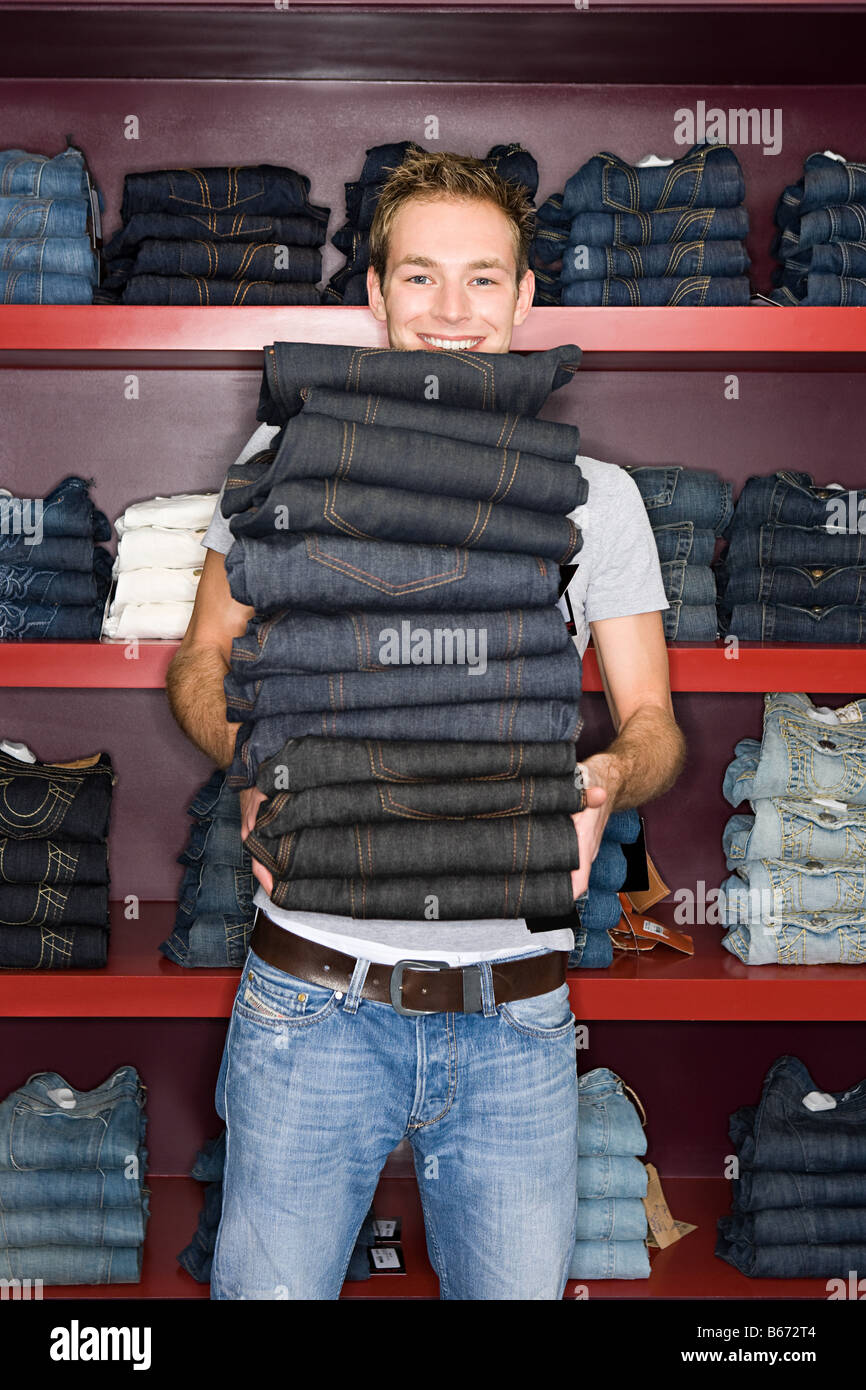 Man holding a stack of jeans Stock Photo - Alamy