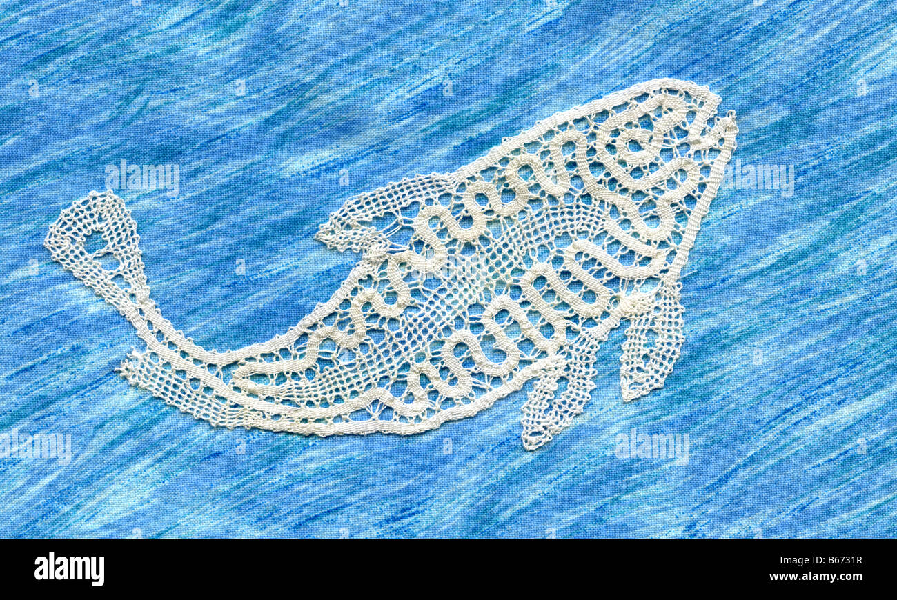 Fish outline facing right in white bobbin lace on mottled blue ...