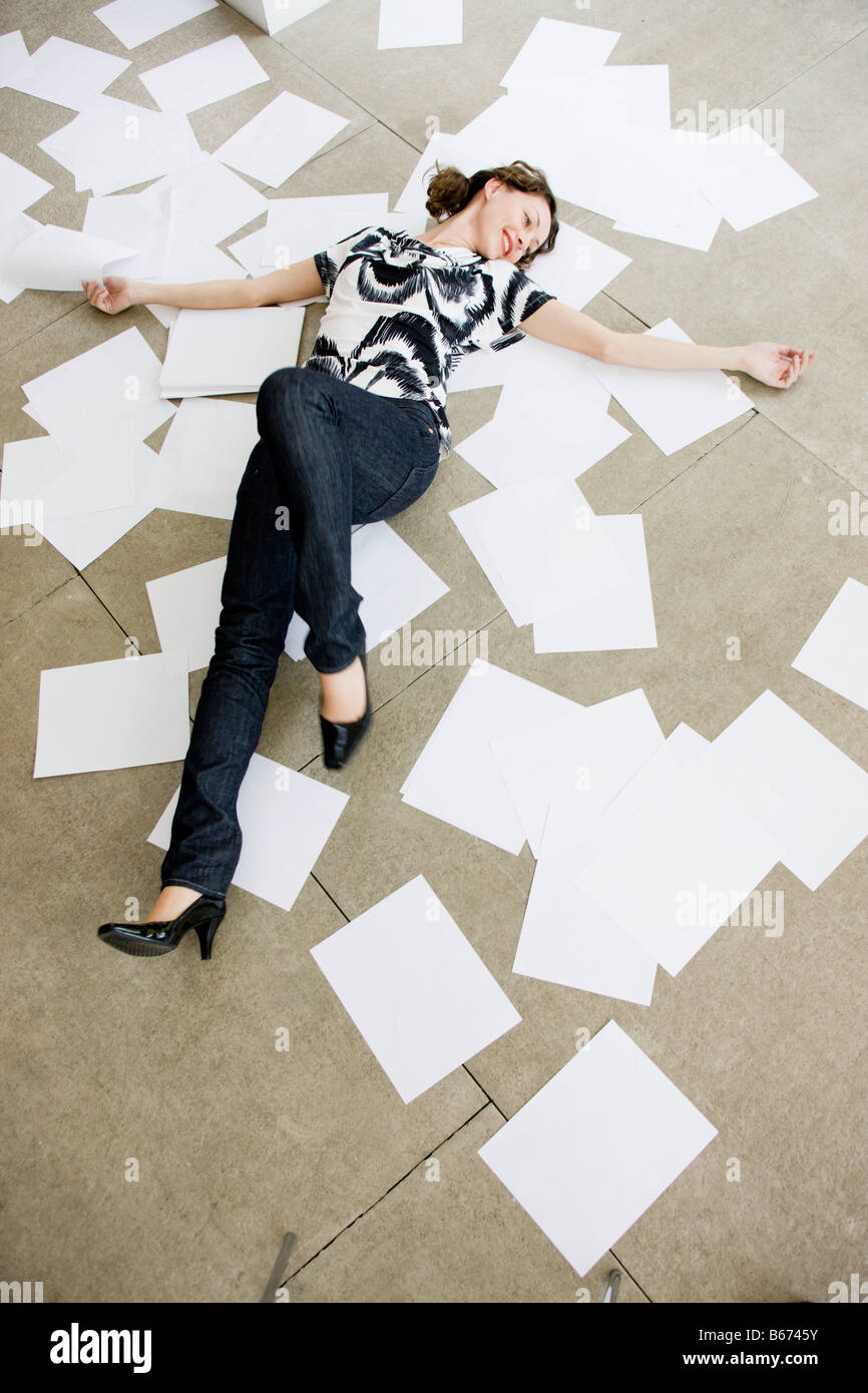 Woman lying between sheets of paper hi-res stock photography and images ...
