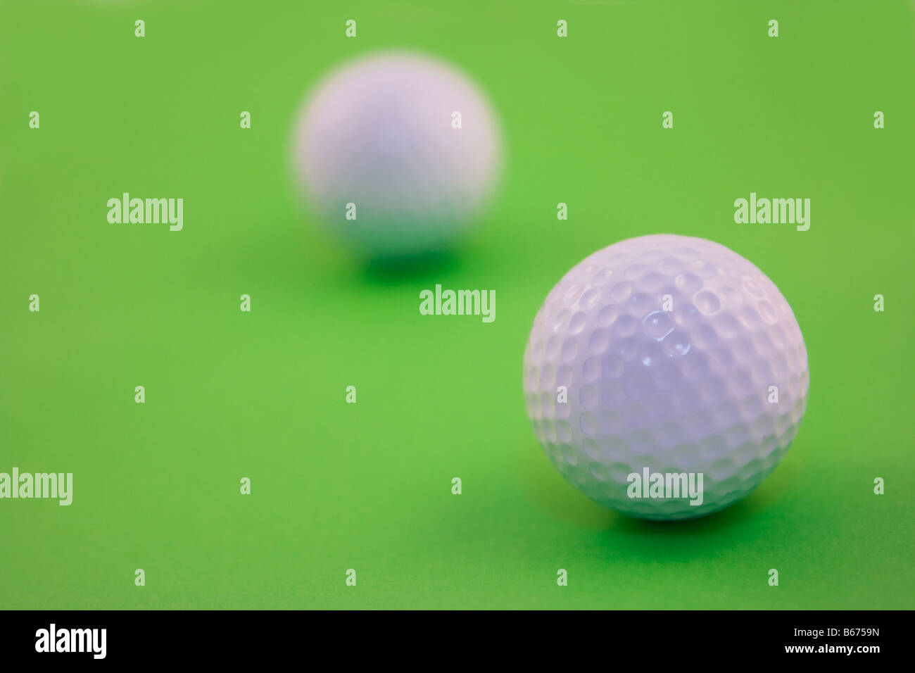 Two golf balls lying on green background Stock Photo - Alamy