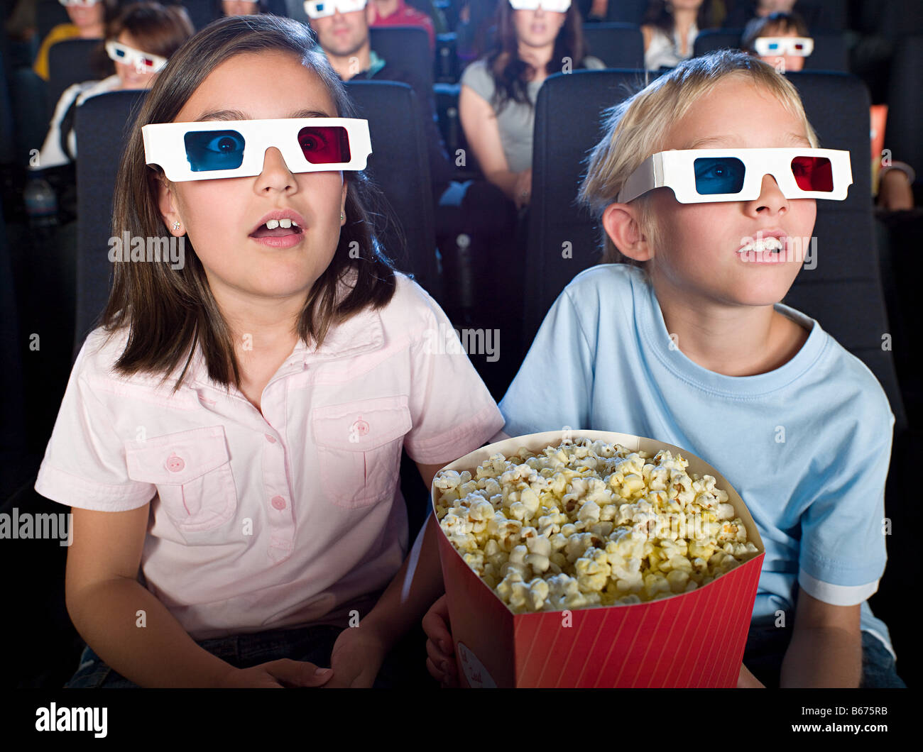 Boy and girl watching a 3d movie Stock Photo - Alamy