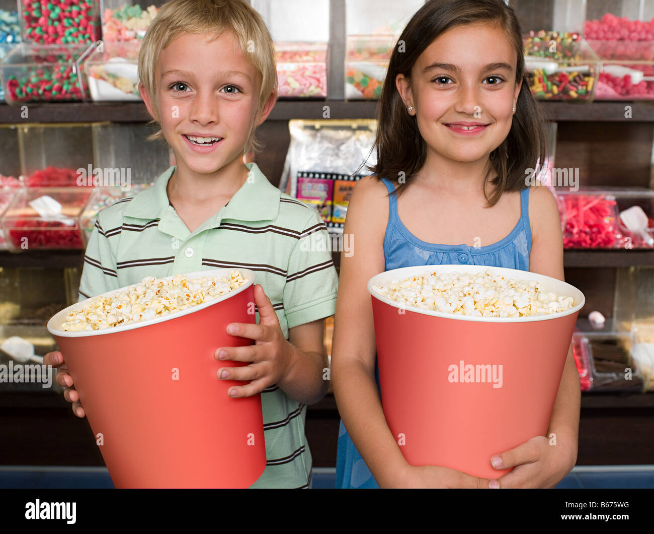 Two children holding tubs of popcorn Stock Photo - Alamy