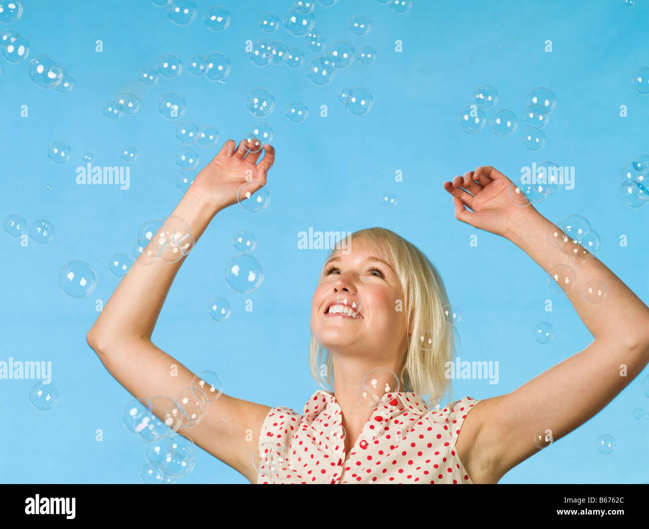 Young woman catching bubbles Stock Photo - Alamy