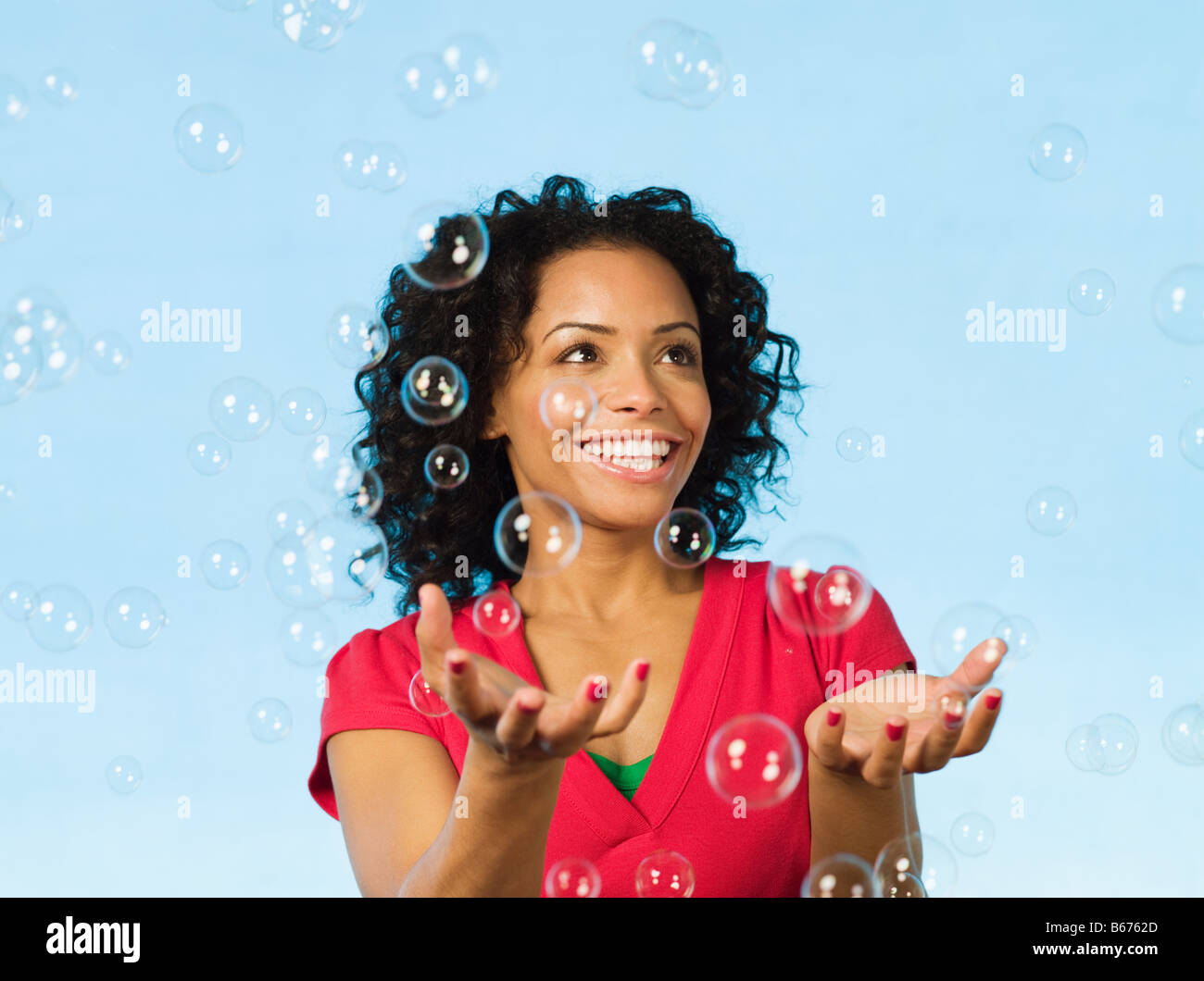 Young woman catching bubbles Stock Photo - Alamy