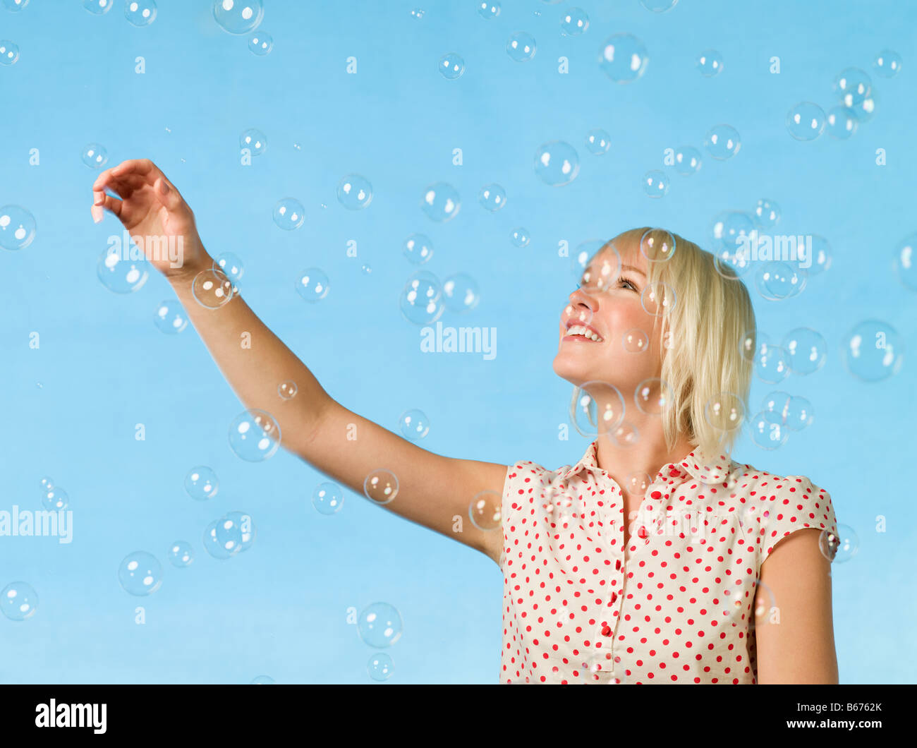 Young woman catching bubbles Stock Photo - Alamy
