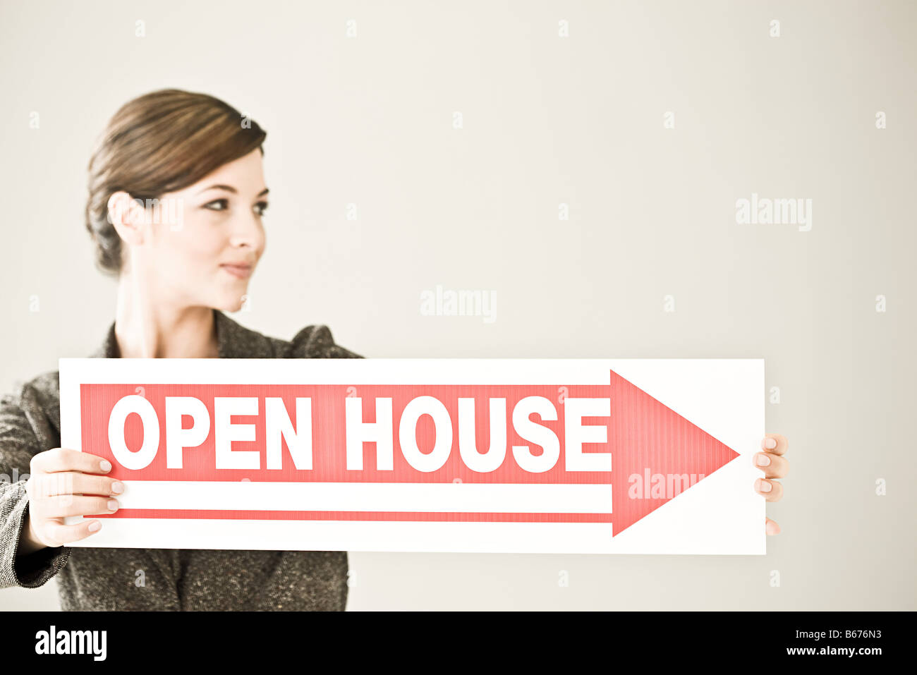 A woman holding an open house sign Stock Photo - Alamy