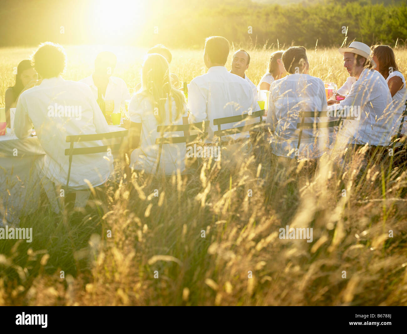 group of people having dinner, sunset Stock Photo - Alamy