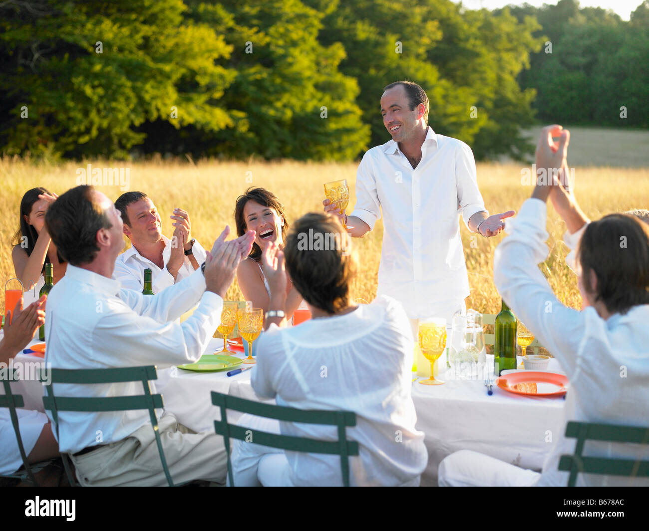 group of people having dinner, sunset Stock Photo - Alamy