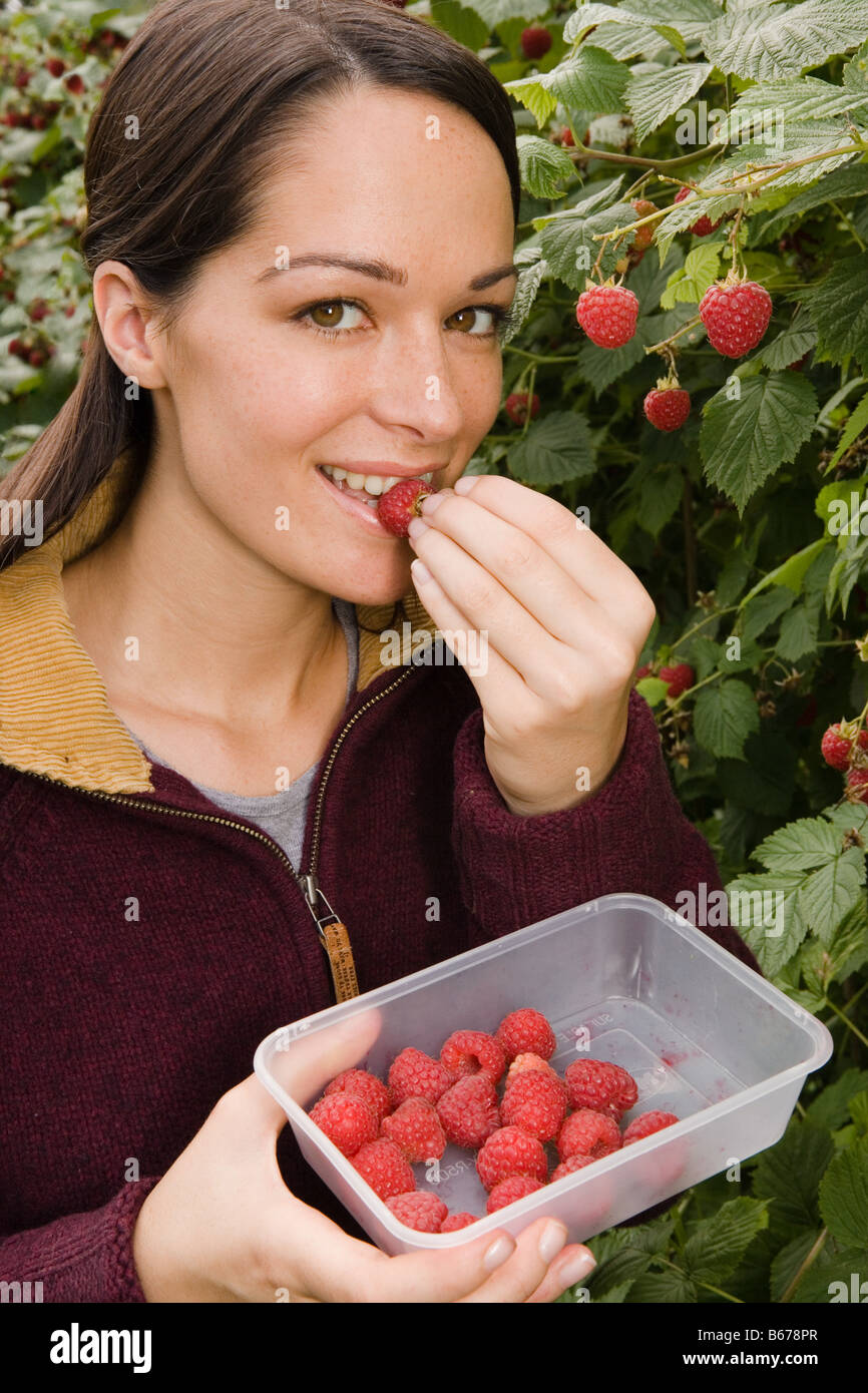 Woman eating fresh raspberries Stock Photo - Alamy