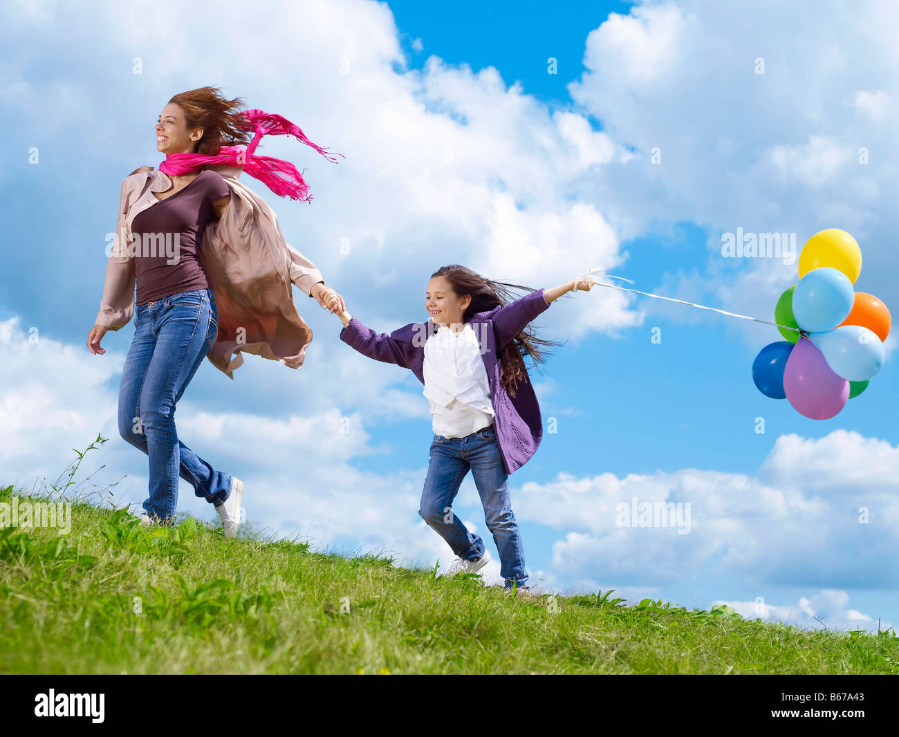 Mother & daughter with balloons in wind Stock Photo - Alamy
