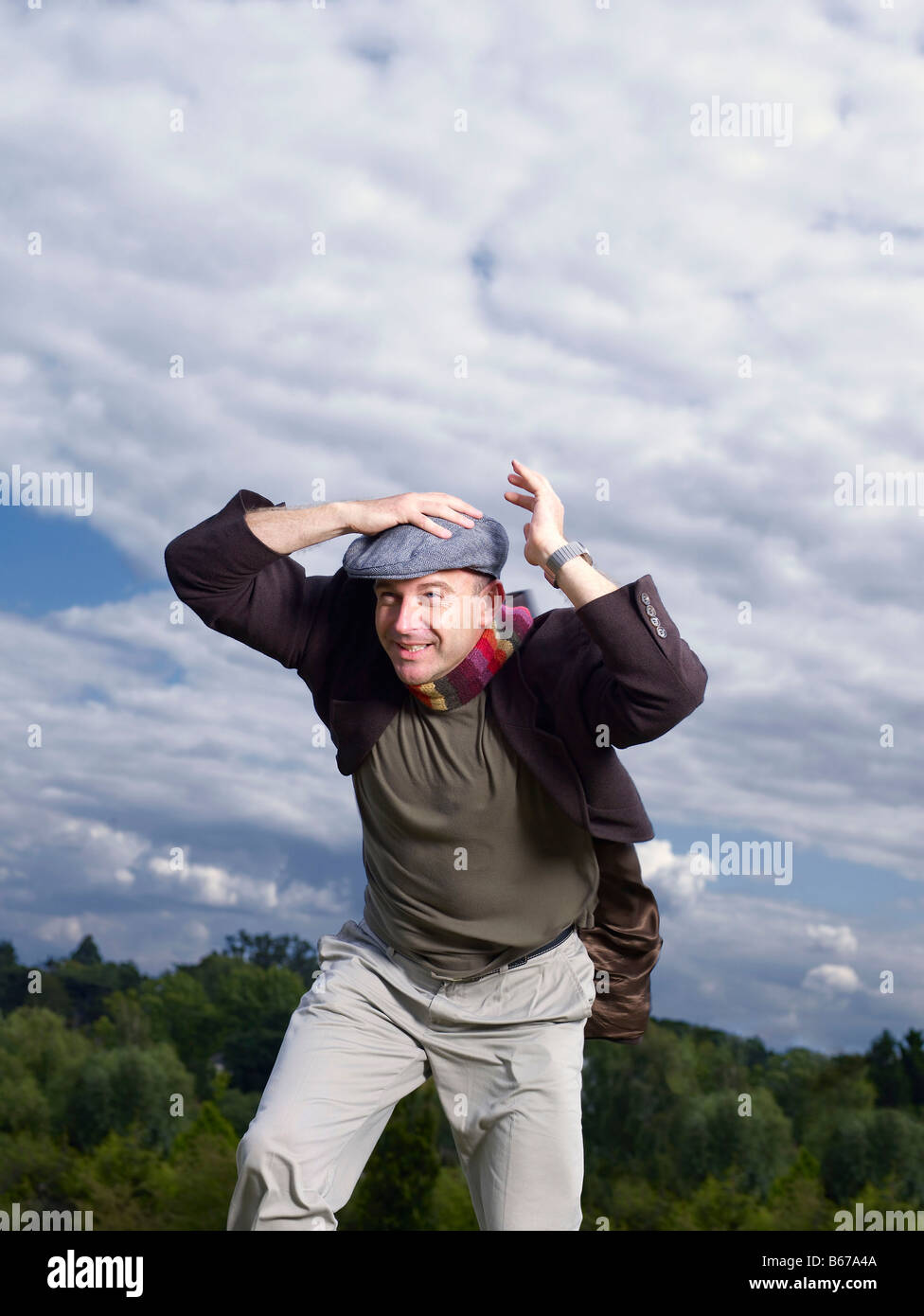 Man holding onto hat in wind Stock Photo - Alamy