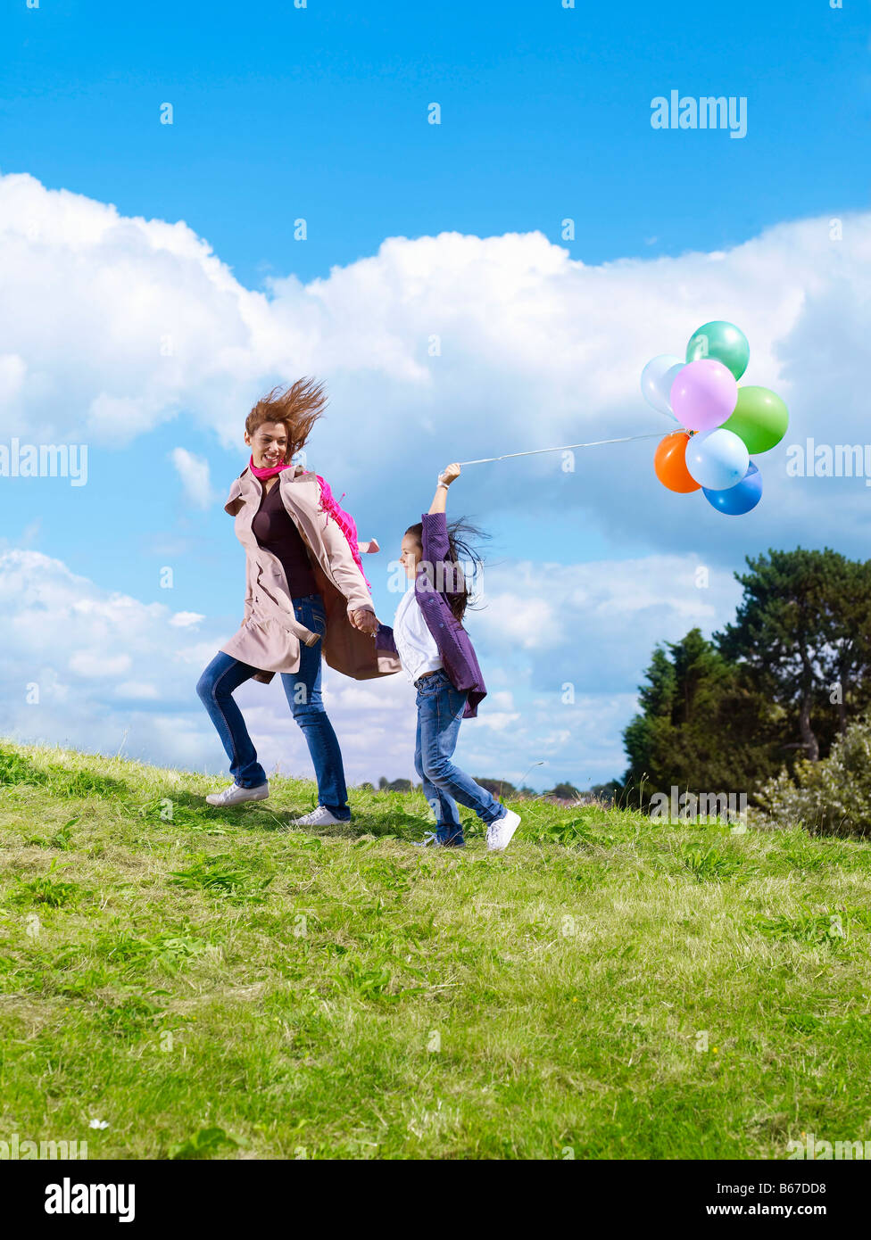 Mother & daughter with balloons in wind Stock Photo - Alamy