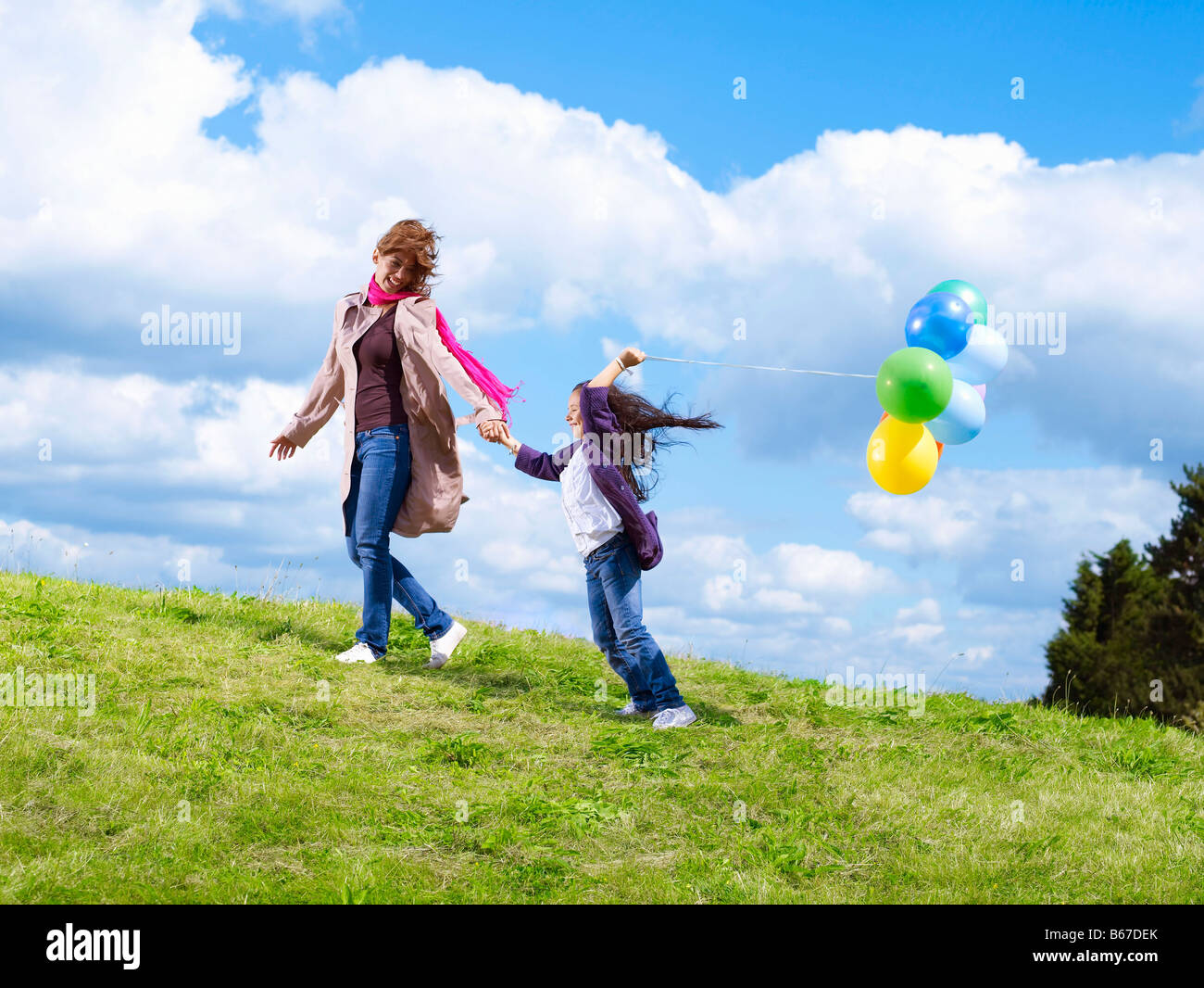 Mother & daughter with balloons in wind Stock Photo - Alamy