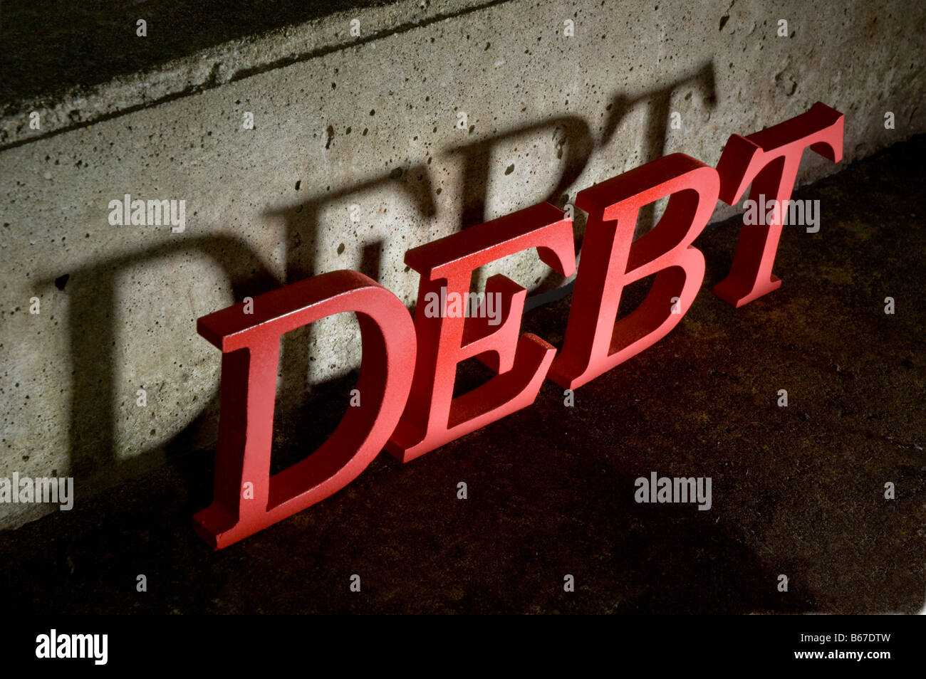 The word debt in red against cold concrete Stock Photo - Alamy