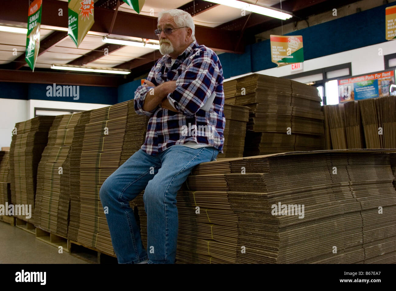 Elderly man sitting on cardboard moving boxes recycling Stock Photo - Alamy