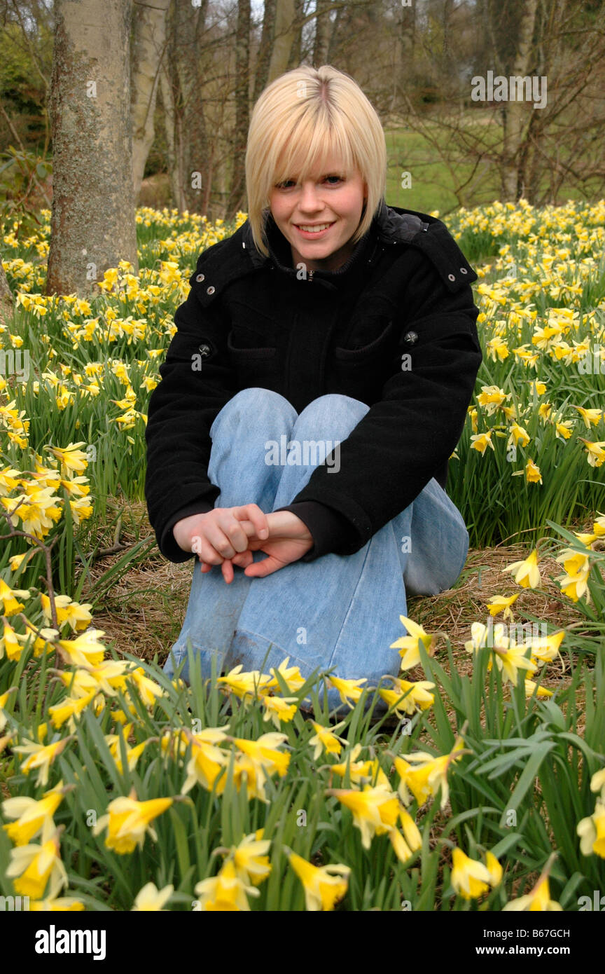 A young woman sits among flowering daffodils Stock Photo - Alamy