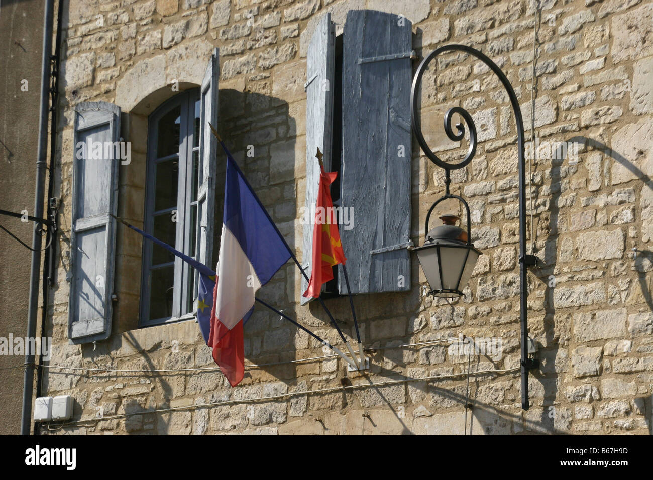 French building with flag and shutters Stock Photo - Alamy