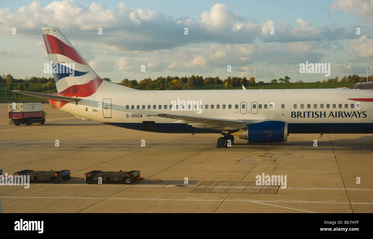Detail of British Airways plane with luggage against blue sky with ...