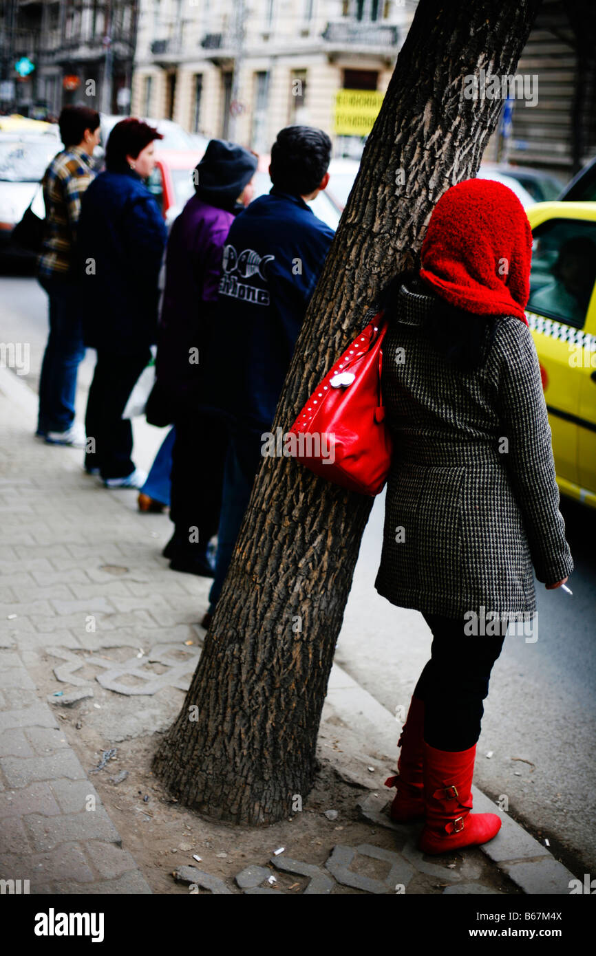 A woman with red accessories waiting for the bus in the city Stock ...