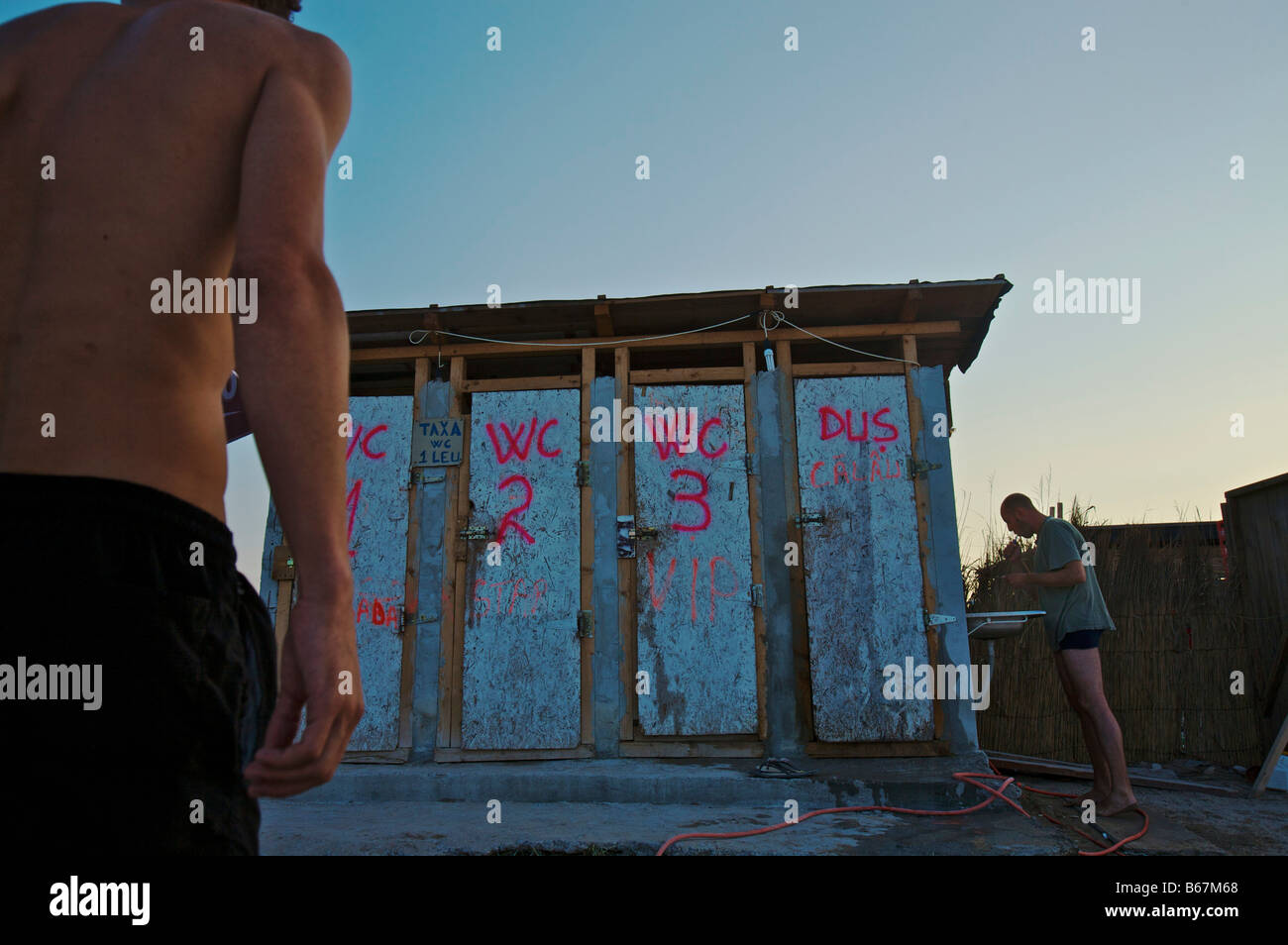 A men is brushing his teeth at an outdoor toilet on the beach Stock ...