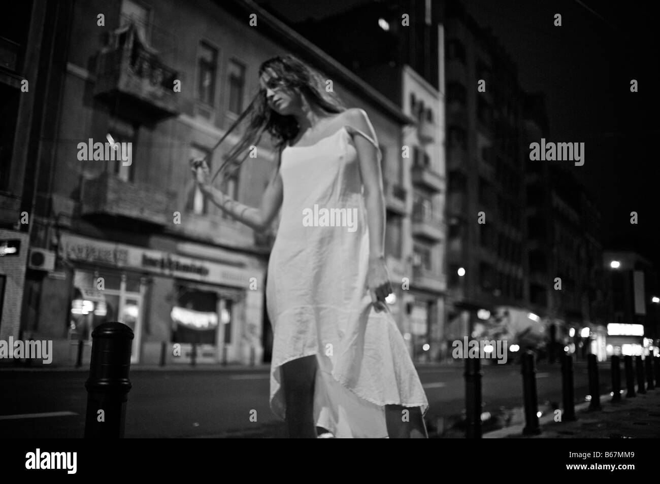 Girl in white dress wandering at night in the city Stock Photo - Alamy