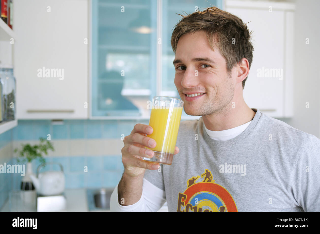 Young man drinking a glass of orange juice, Munich, Germany Stock Photo ...