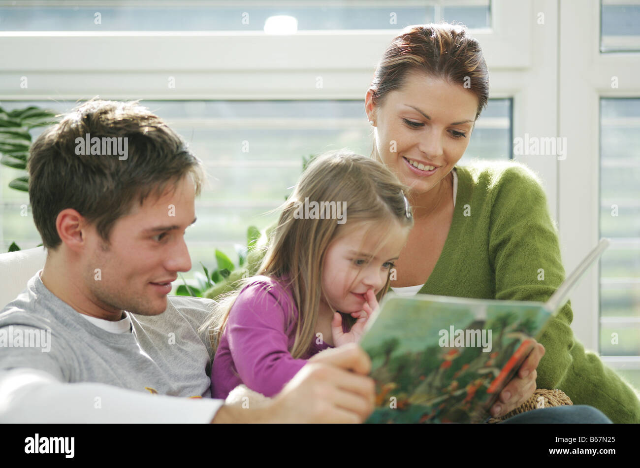 Family reading a book, Munich, Germany Stock Photo - Alamy
