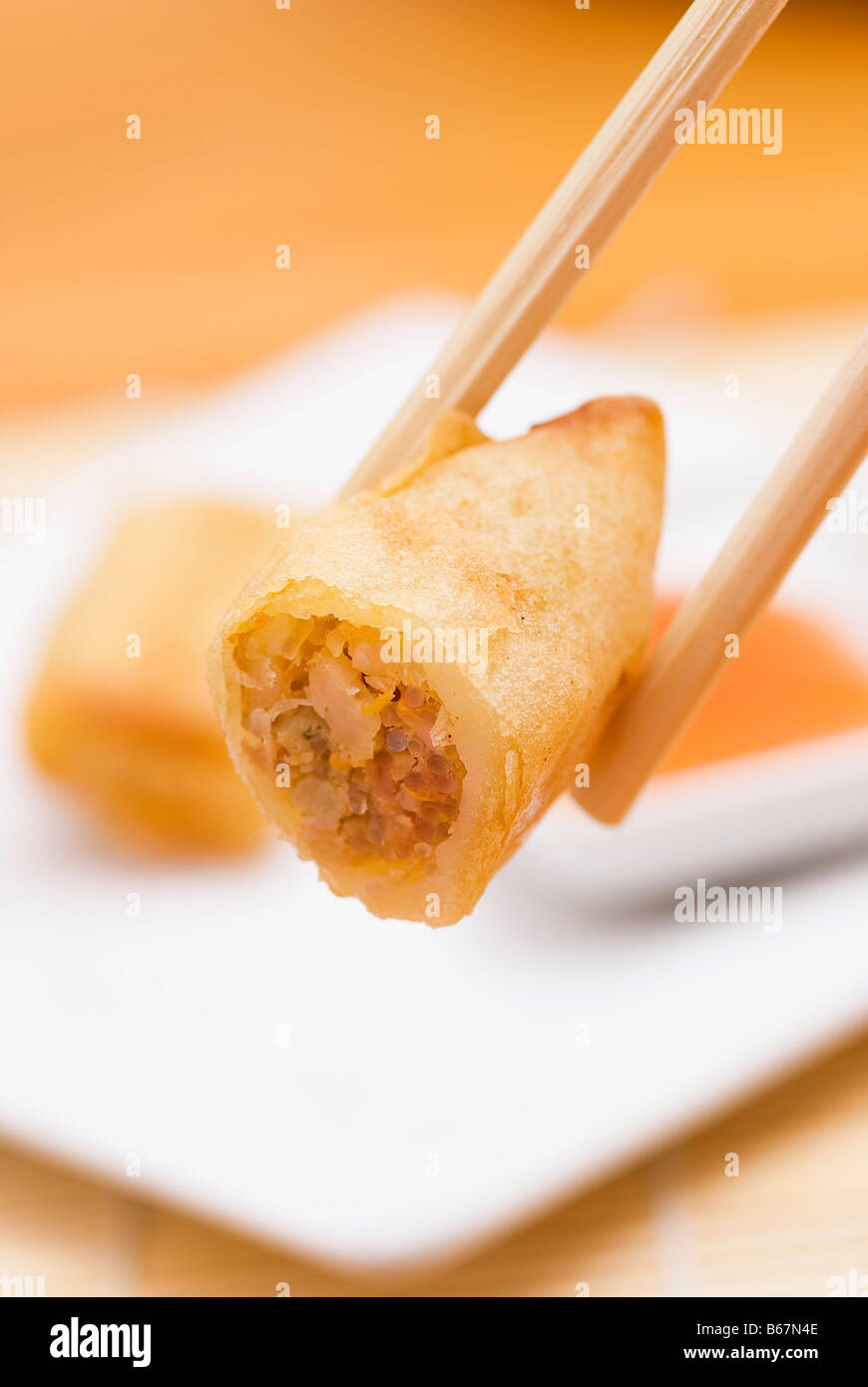 Close-up of a spring roll held in chopsticks Stock Photo - Alamy