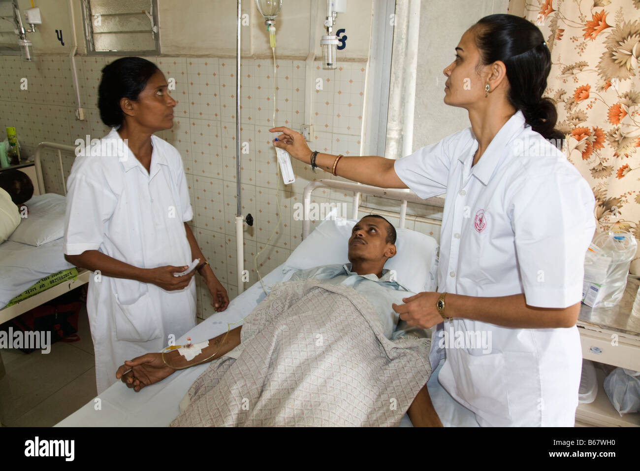 Nurses treating a patient with an intraveinous drip on a general ward ...