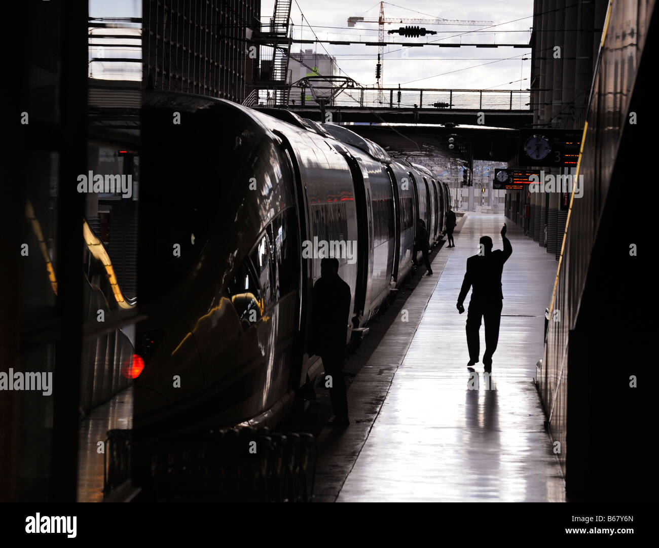 A man signals the train driver on an Ave high-speed train at Atocha ...