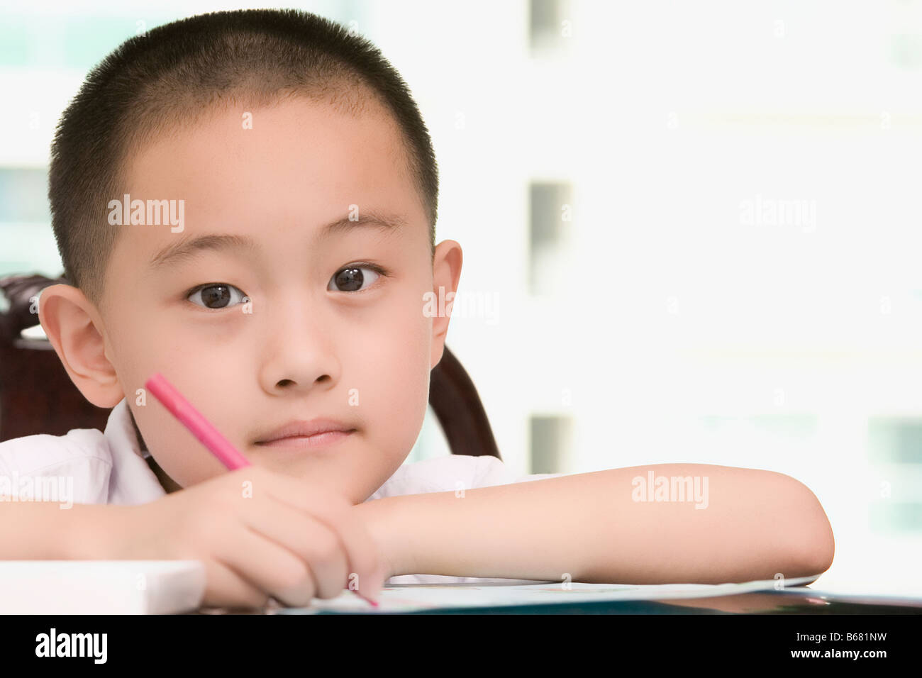 Portrait of a boy writing on a sheet of paper Stock Photo - Alamy