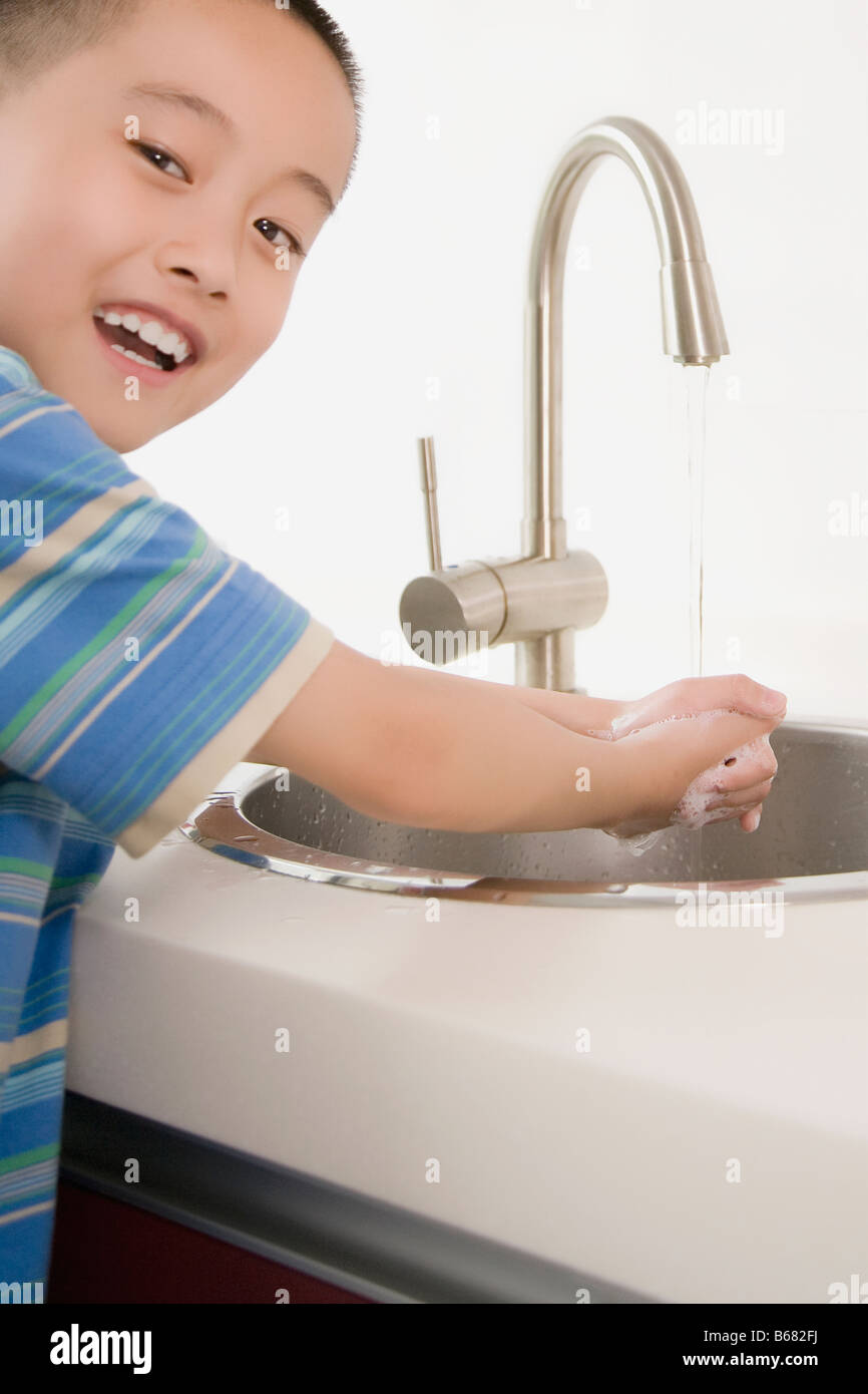 Portrait of a boy washing his hand and smiling Stock Photo - Alamy