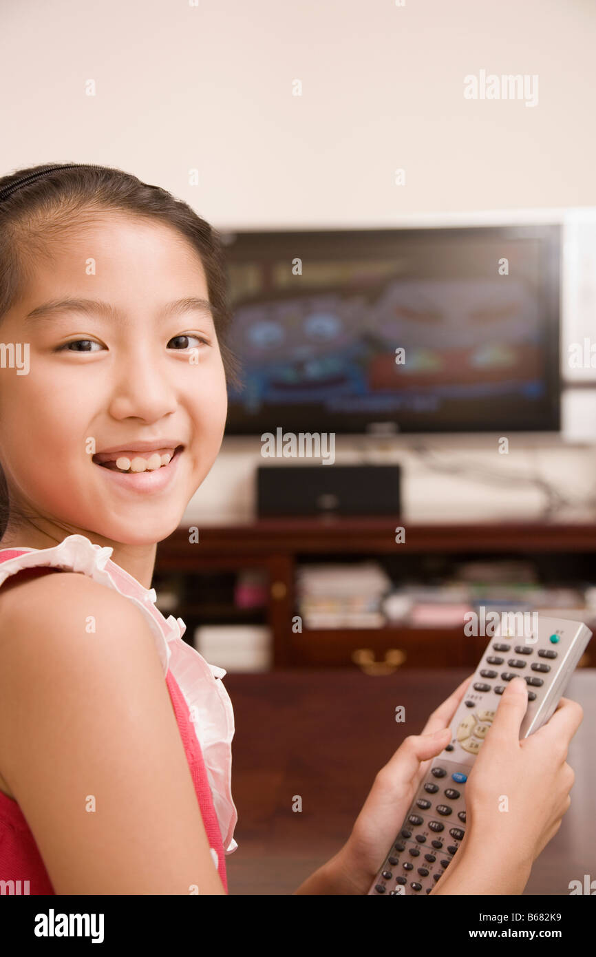 Portrait of a girl holding a remote control and smiling Stock Photo - Alamy