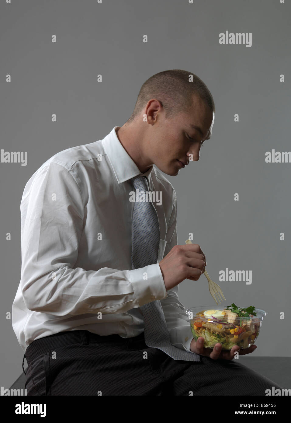 Business man eating salad Stock Photo - Alamy