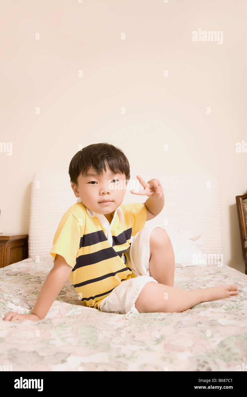 Portrait of a boy showing a peace sign and smiling Stock Photo - Alamy
