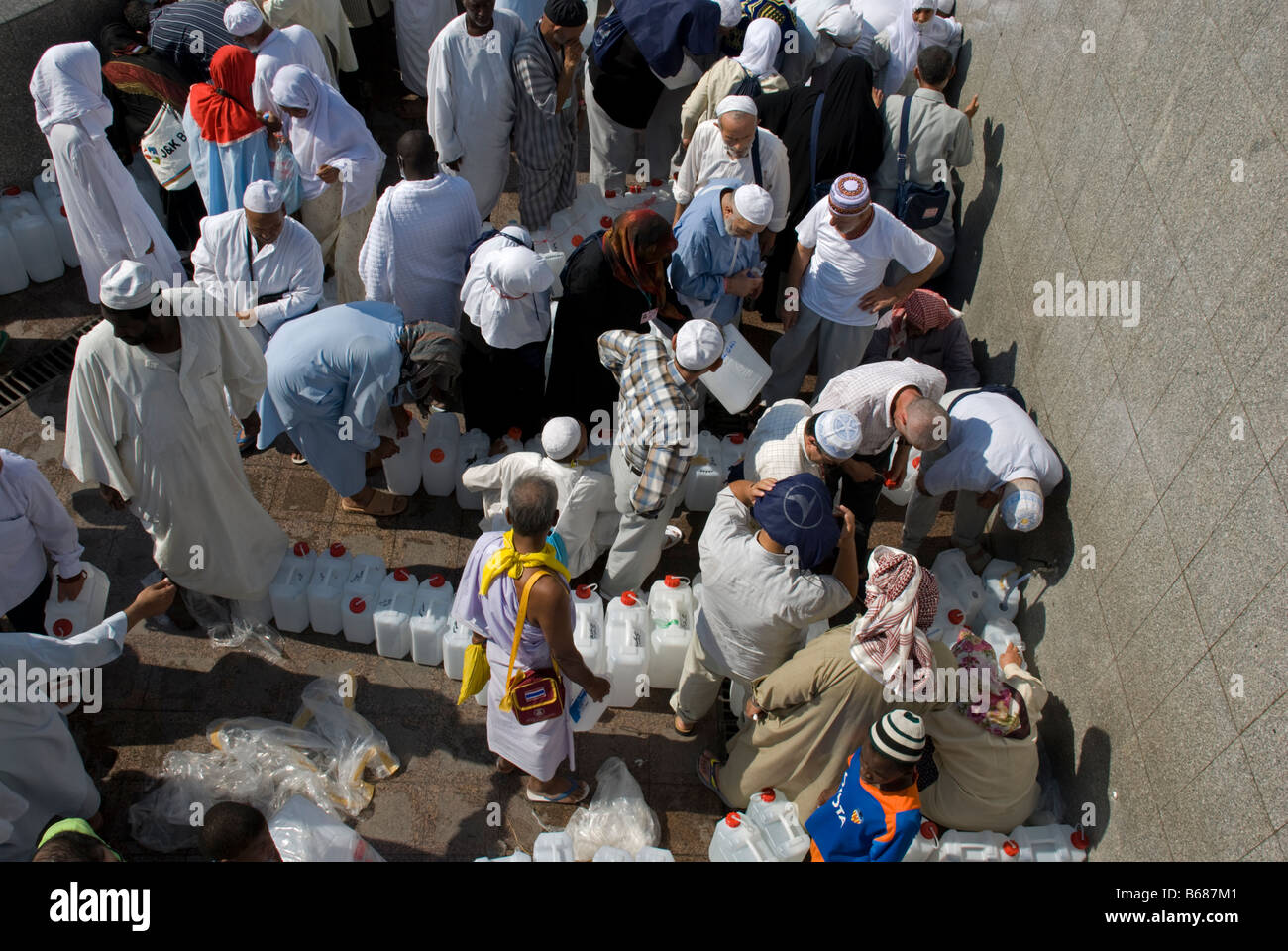 Muslim pilgrims filling Zam Zam water in their plastic containers to be ...