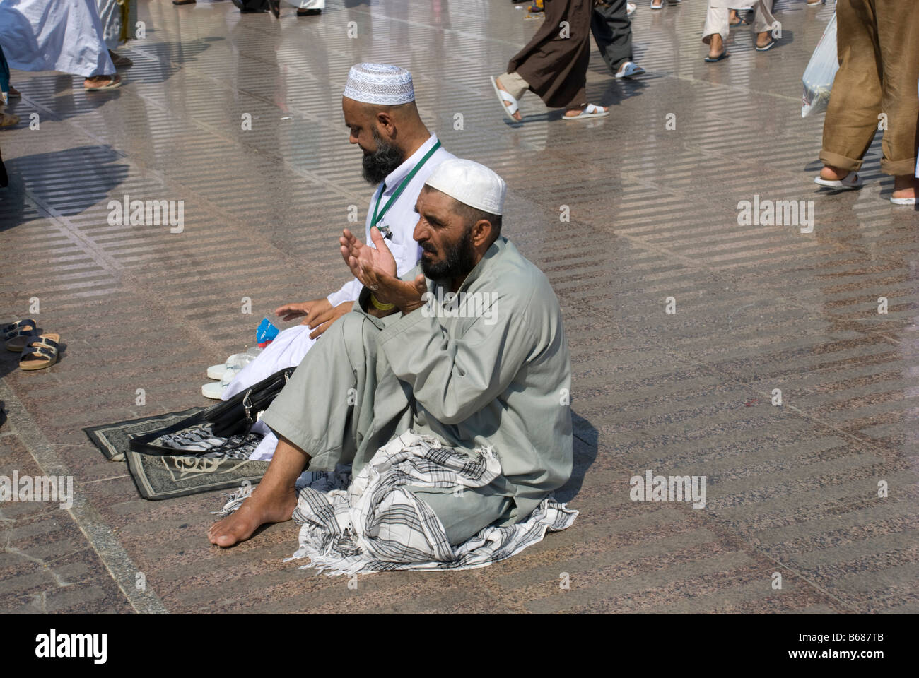 Two men sitting after the noon prayer dhur where one is making ...