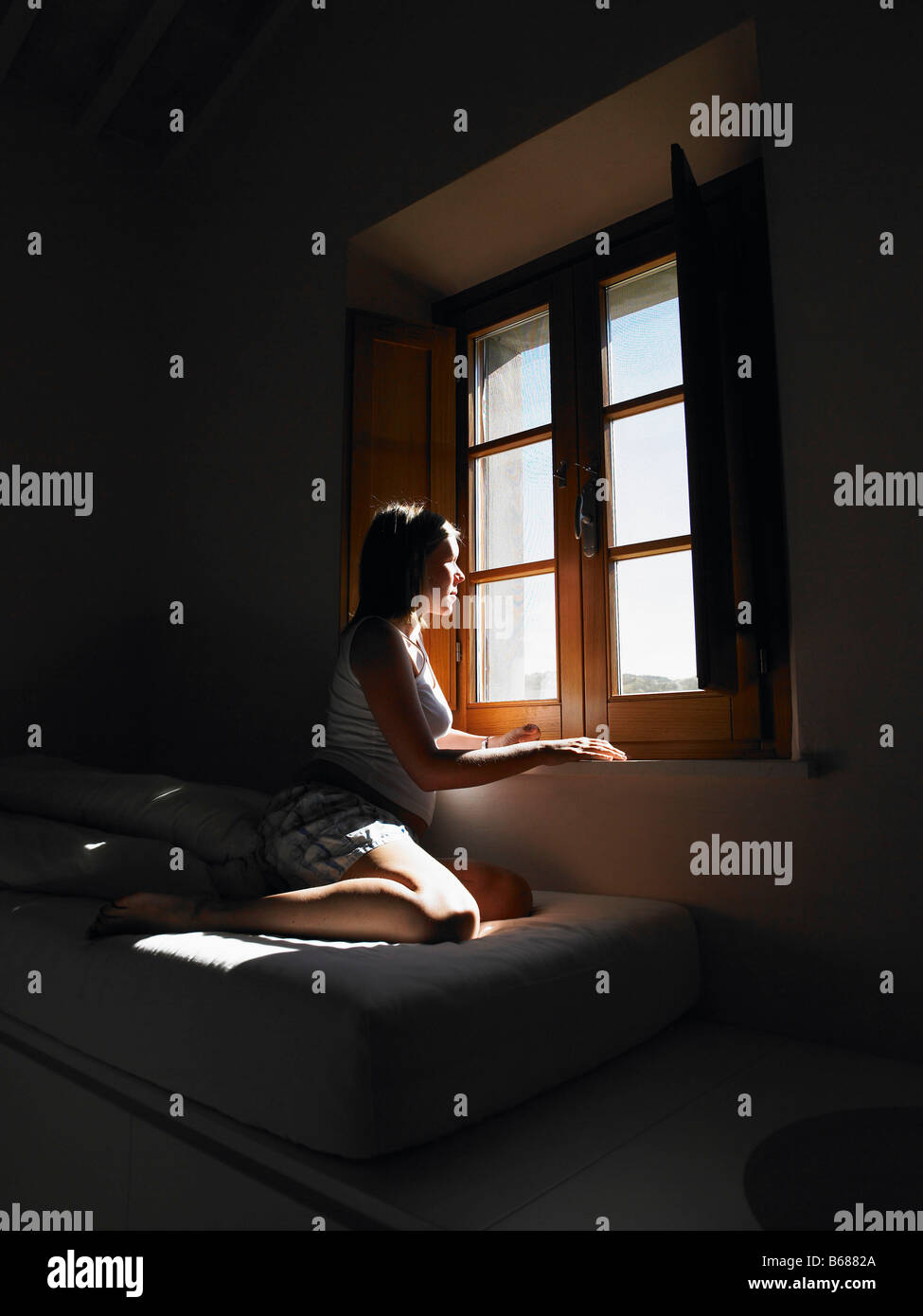 Woman looking through window Stock Photo - Alamy