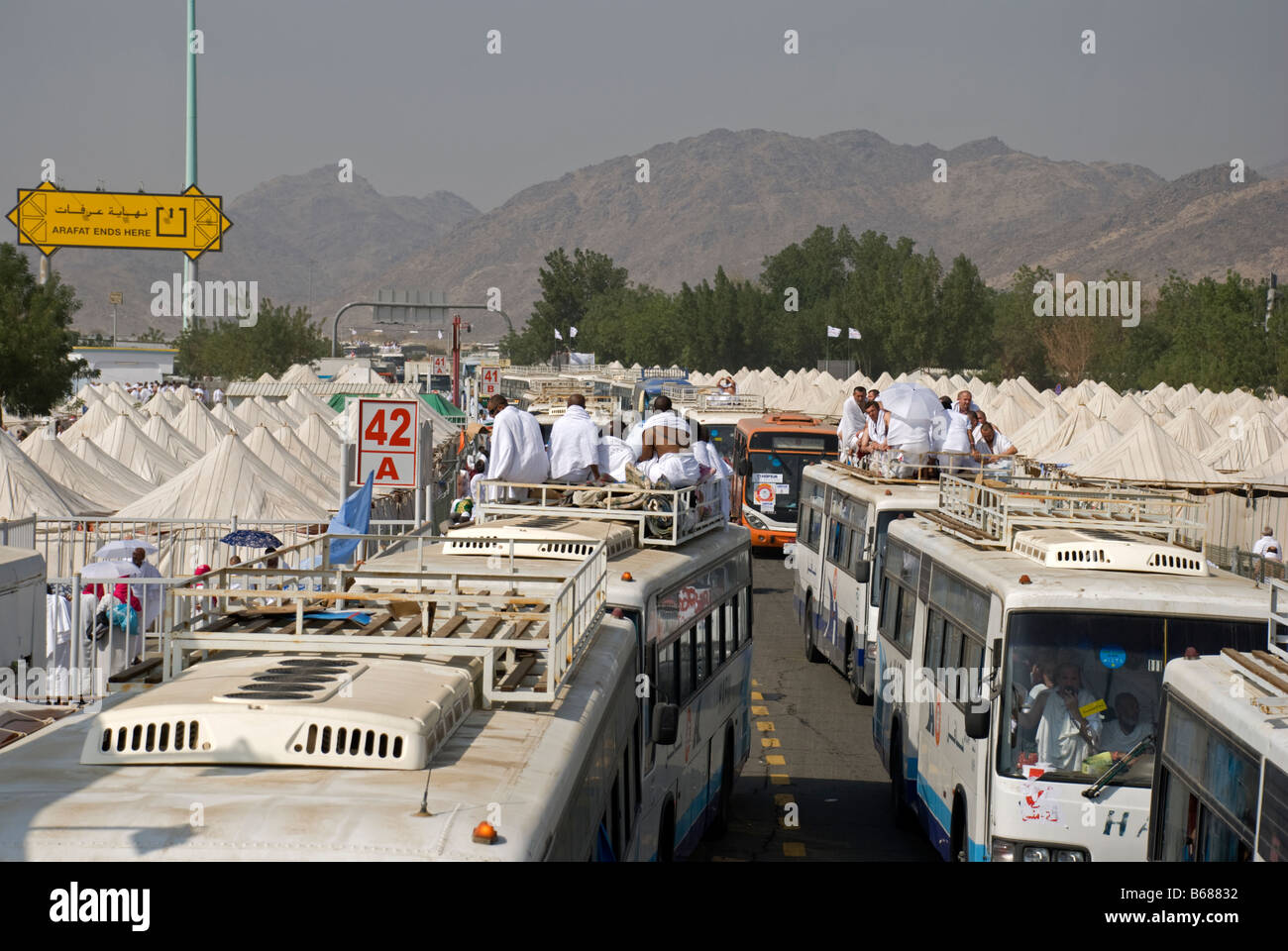 Muslim pilgrims arriving at the plains of Arafat on the roof of buses ...