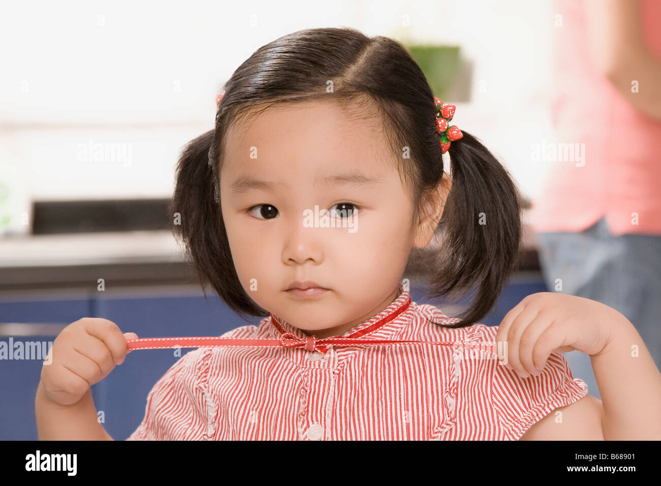 Portrait of a girl thinking with her mother standing behind her Stock ...