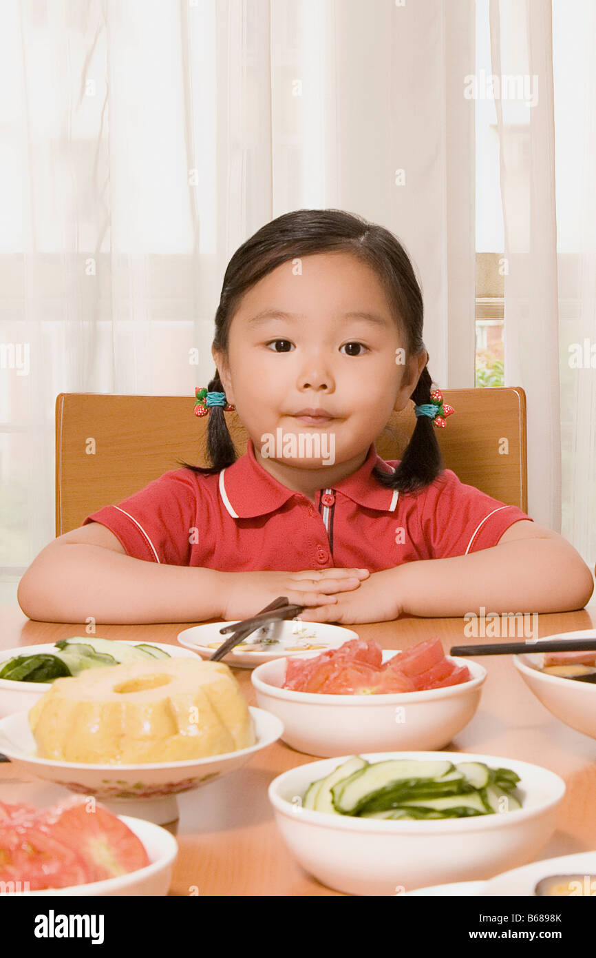 Portrait of a girl sitting at a dining table Stock Photo - Alamy