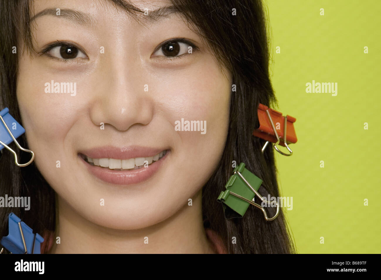 Portrait of a young woman smiling with paper clips in her hair Stock ...