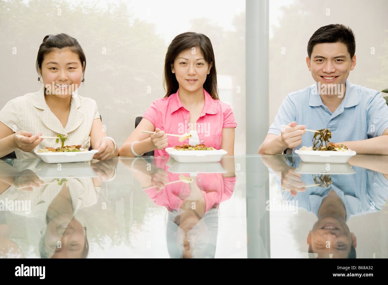 Portrait of three office workers having lunch and smiling Stock Photo ...