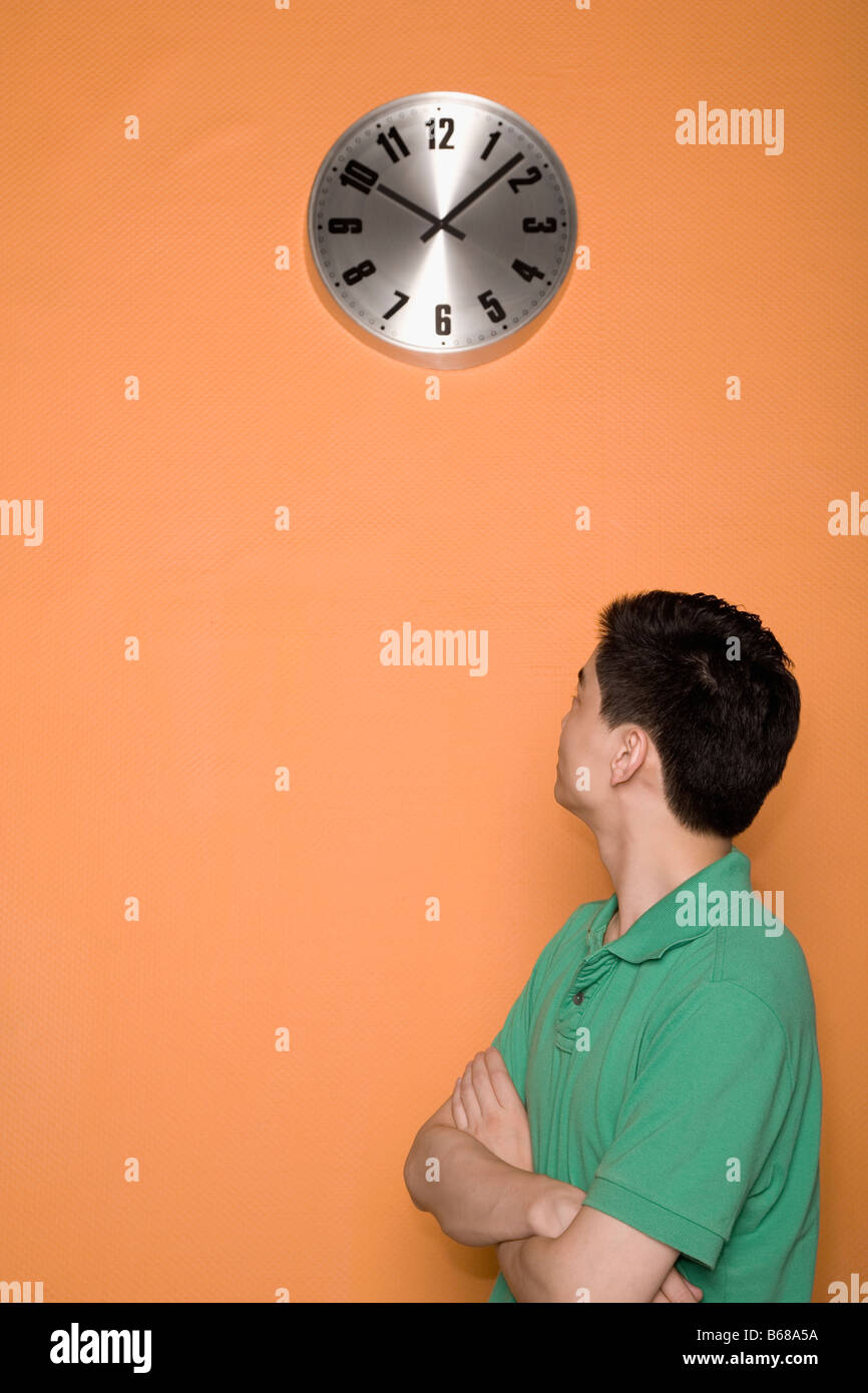 Side profile of a male office worker looking at a clock Stock Photo - Alamy