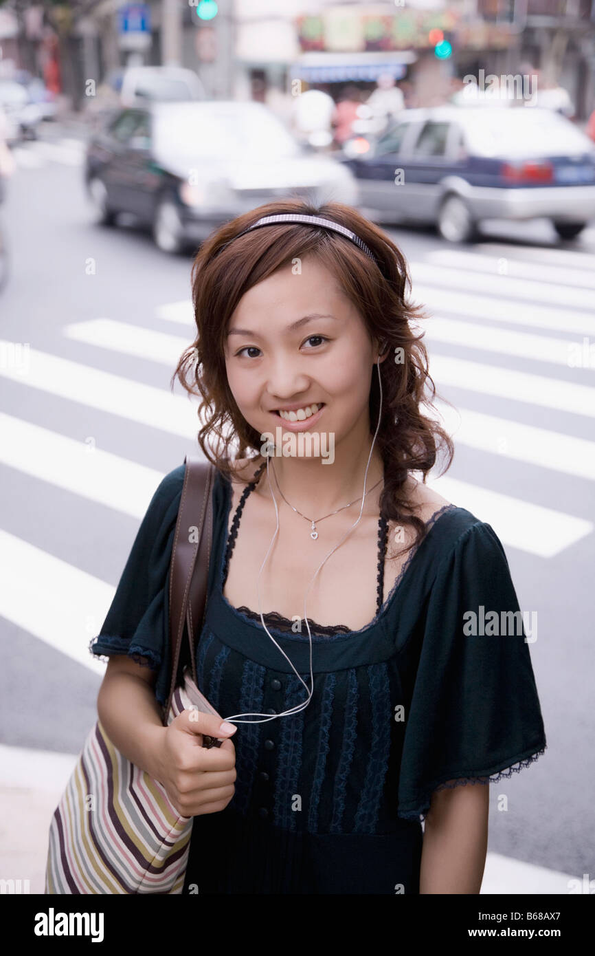 Portrait of a young woman carrying a shoulder bag and smiling Stock ...