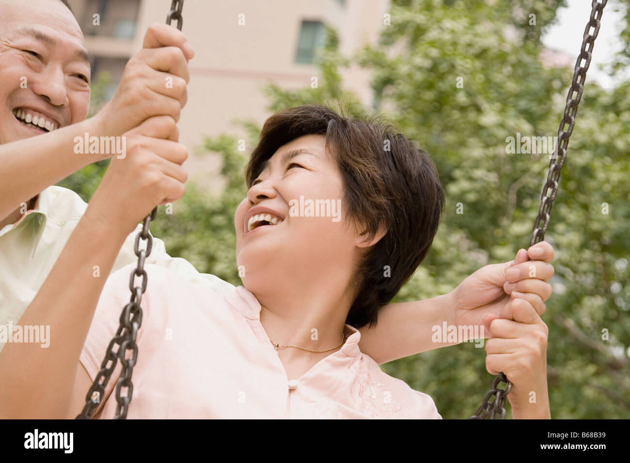 Man pushing a woman on a swing hi-res stock photography and images - Alamy
