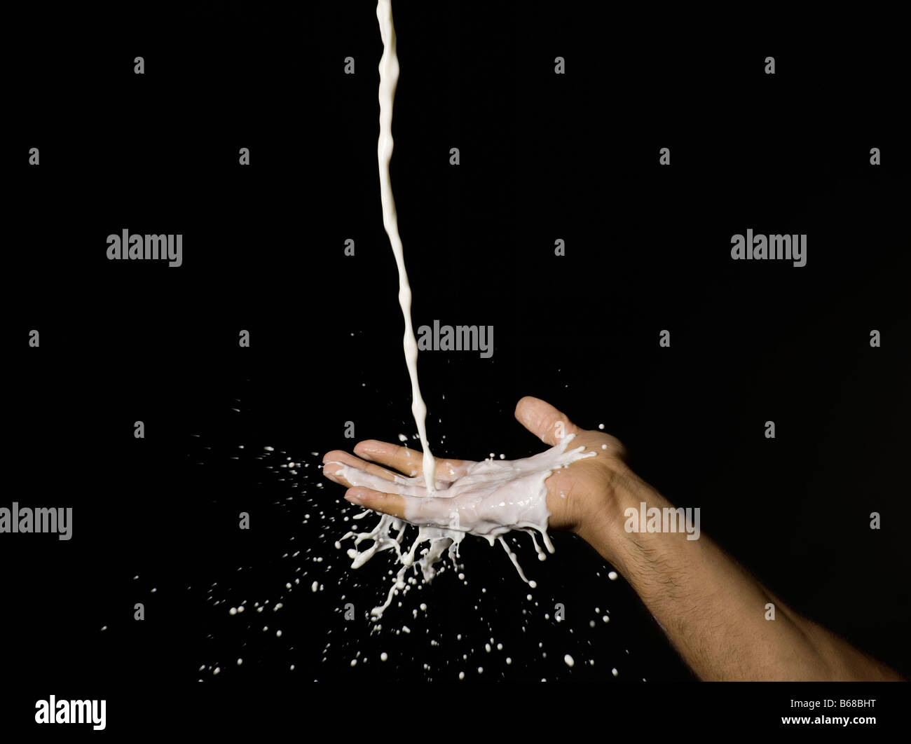 White liquid falling on man's hand Stock Photo - Alamy
