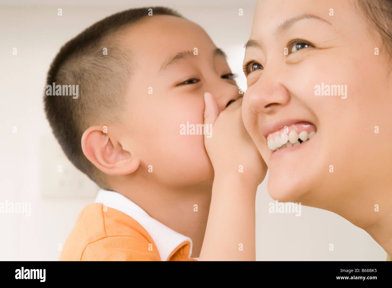 Close-up of a boy whispering to his mother Stock Photo - Alamy