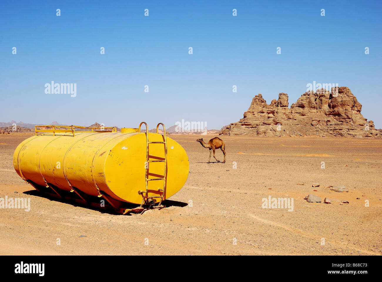 Desertscape with a yellow tank and camel Stock Photo - Alamy