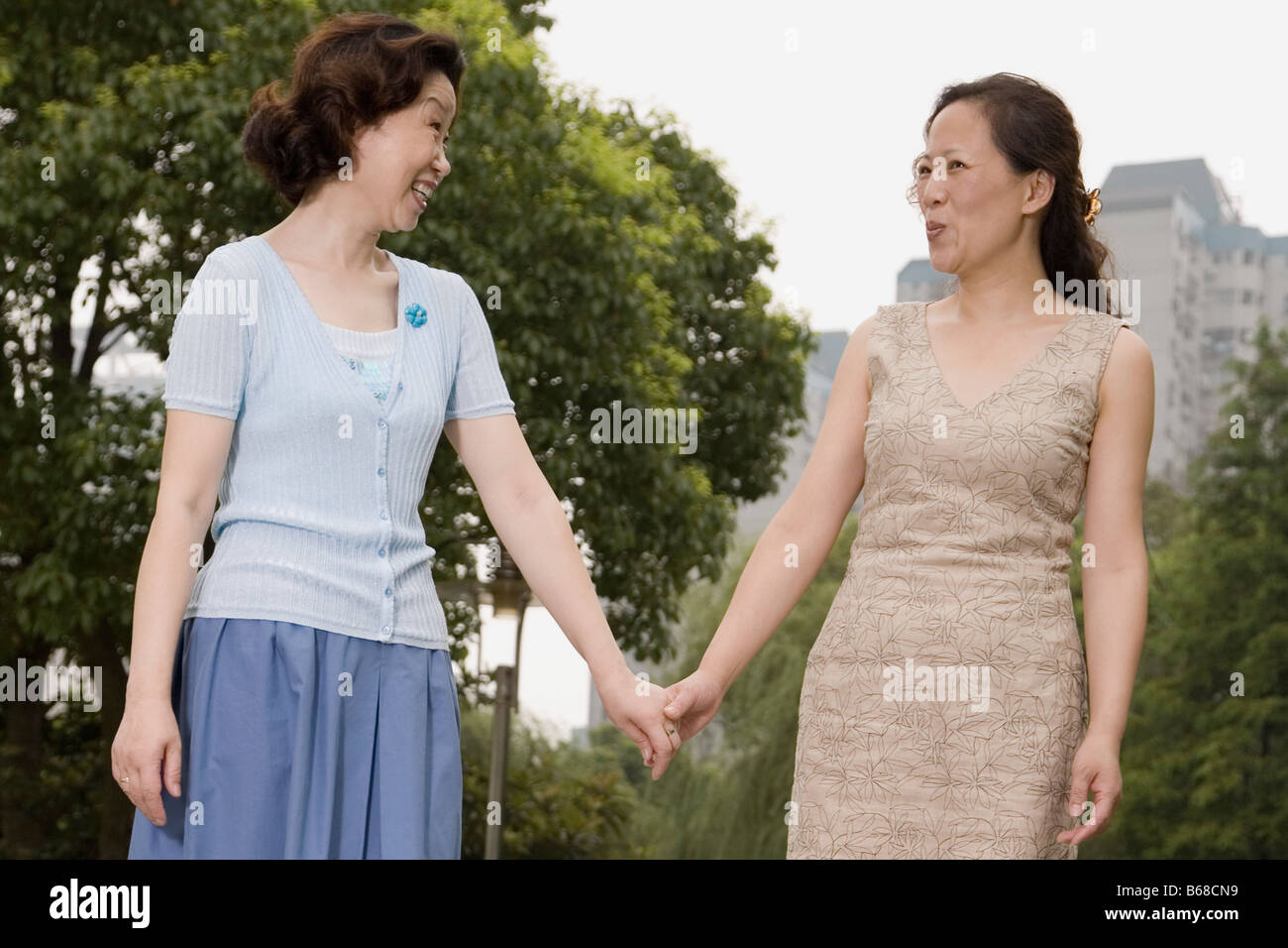 Two mature women holding hands Stock Photo - Alamy